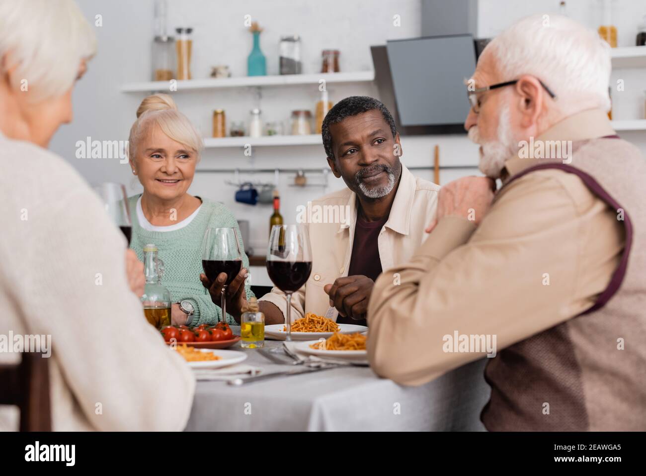 happy multicultural and senior people looking at retired man while ...