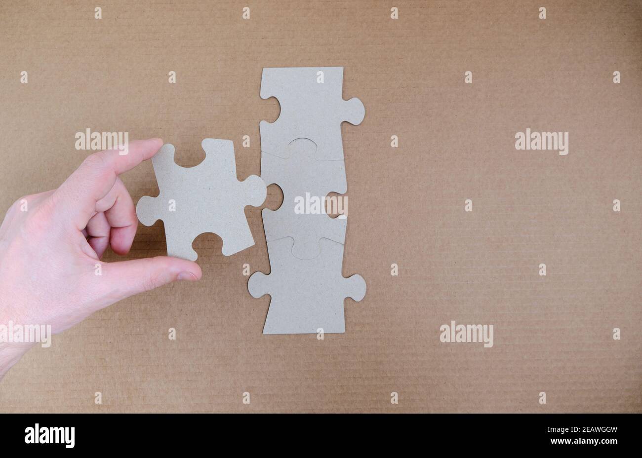 Man's hand attaches the missing piece of the puzzle Stock Photo - Alamy