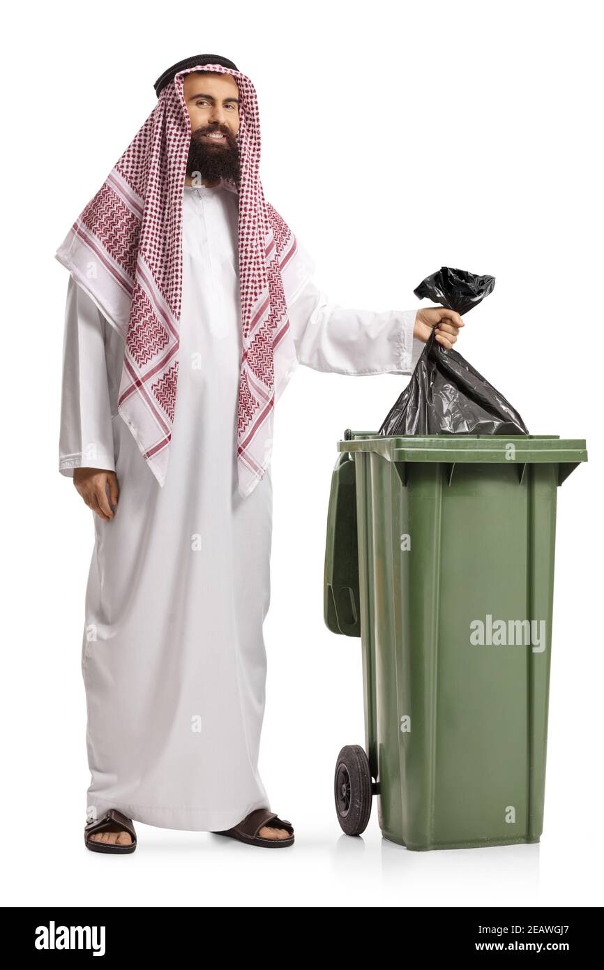Full length portrait of a saudi arab man throwing a waste bag in a bin ...