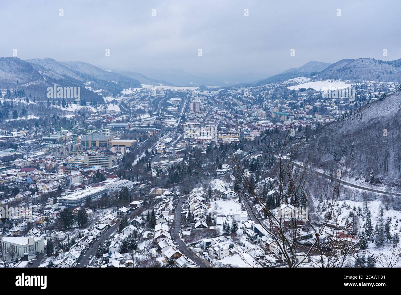 Aerial shot of a city surrounded by hills captured on a cold, snowy day ...