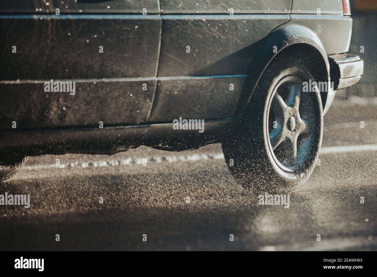 Black car driving on a wet road Stock Photo - Alamy