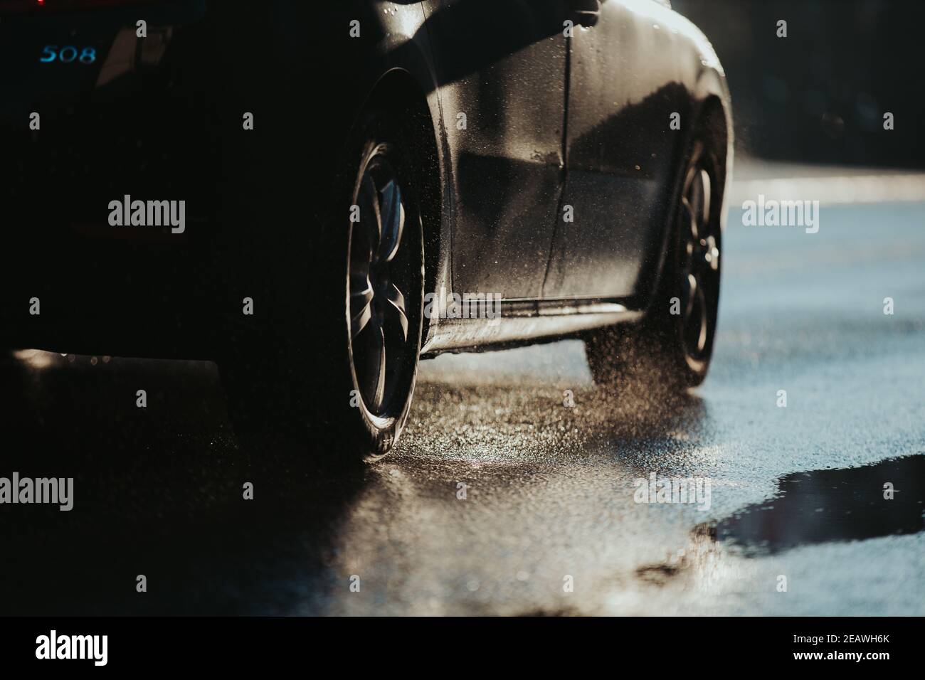 Black car driving on a wet road Stock Photo - Alamy