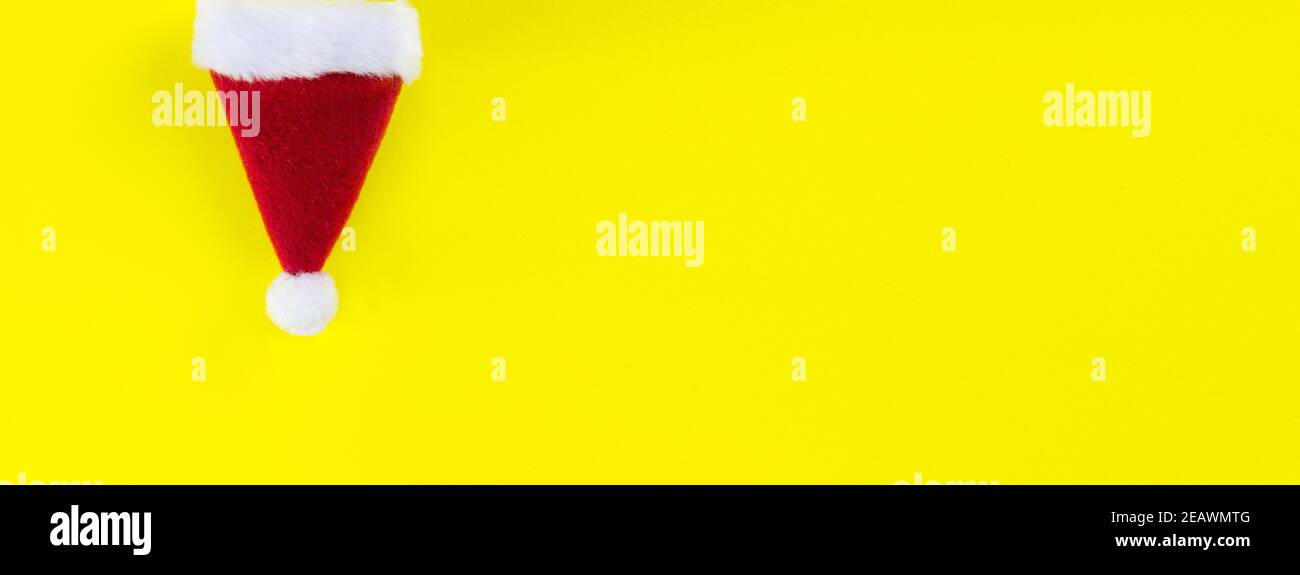 Inverted Santa's red hat on yellow background Stock Photo - Alamy