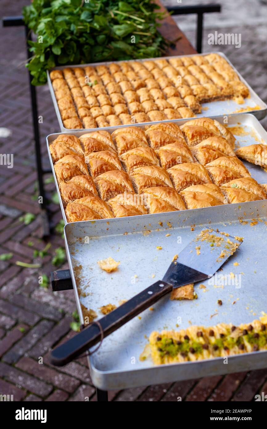 Freshly baked baklava displayed at a stand, outside with fresh mint on ...