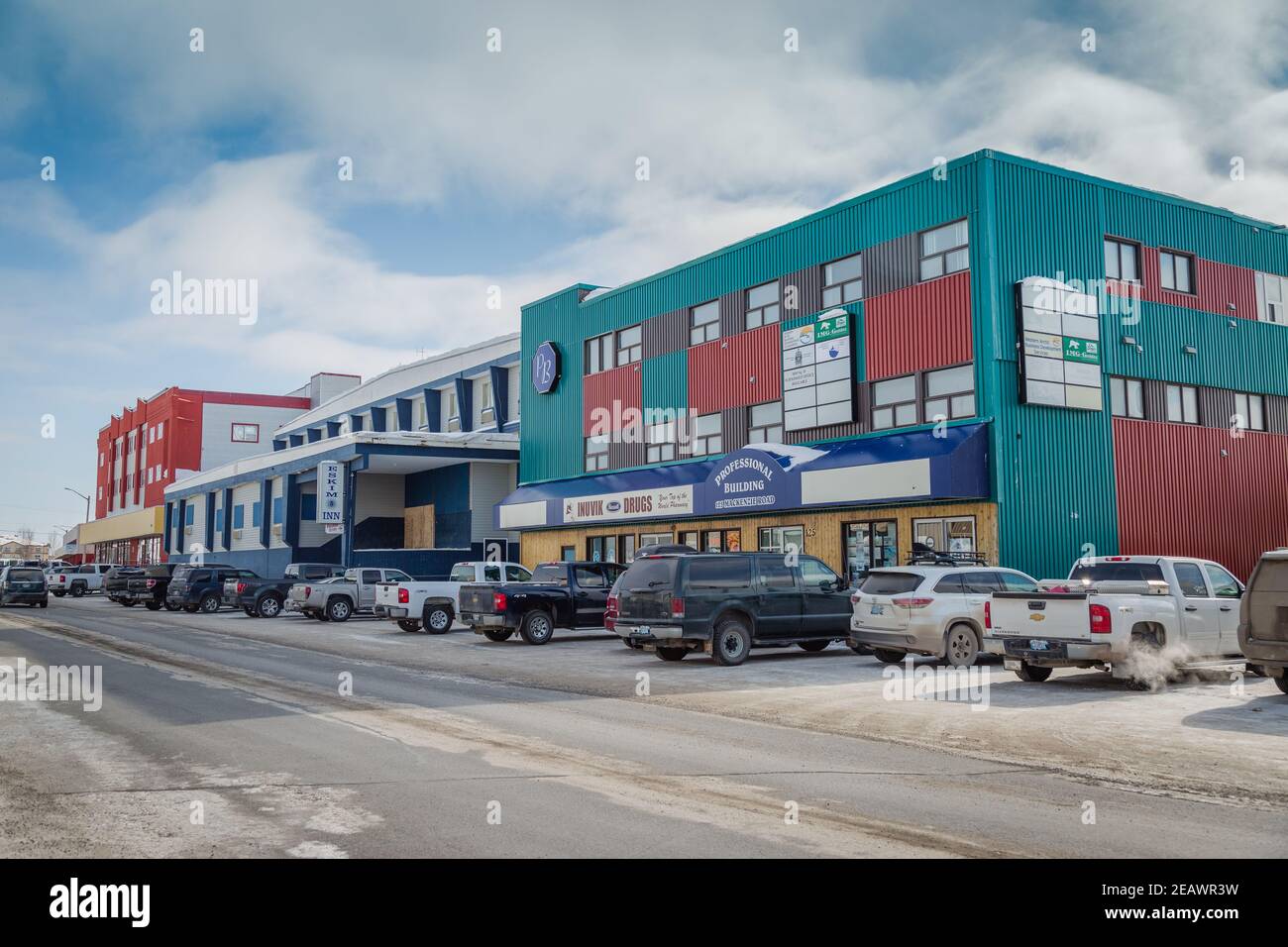 Vehicles parked outside of buildings in downtown Inuvik in winter ...