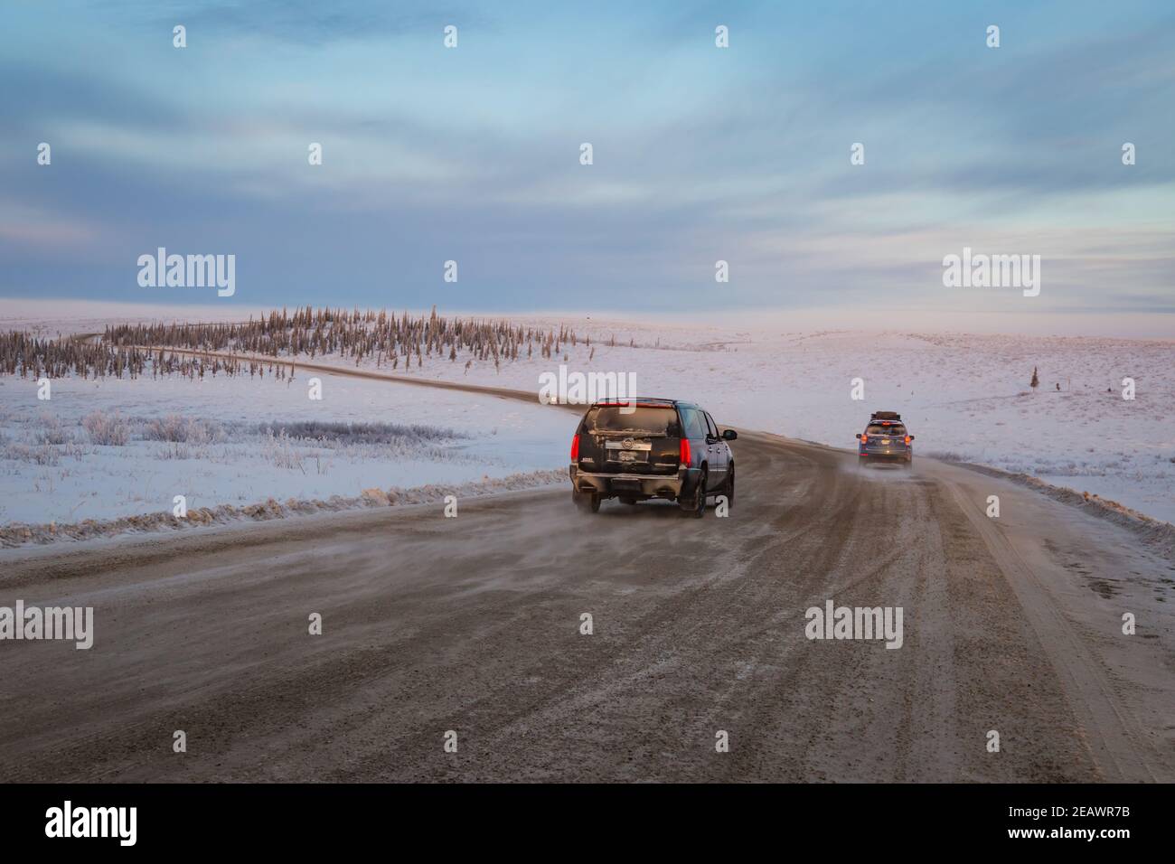 Vehicles driving up the gravel Inuvik-Tuktoyaktuk Highway (built above ...