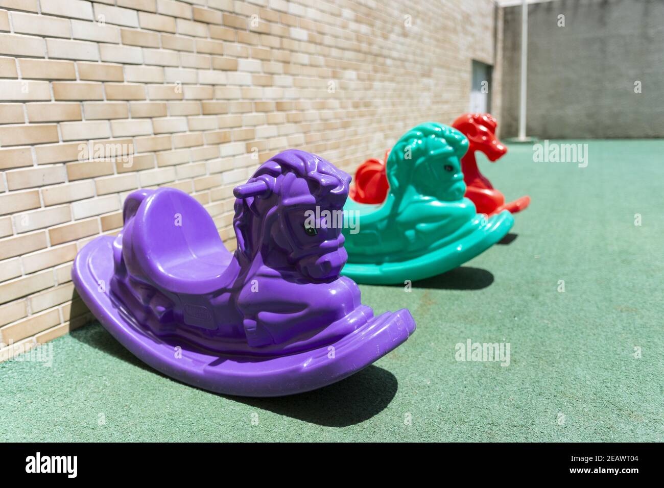 Colorful plastic horse rocking chairs in the playground Stock Photo - Alamy