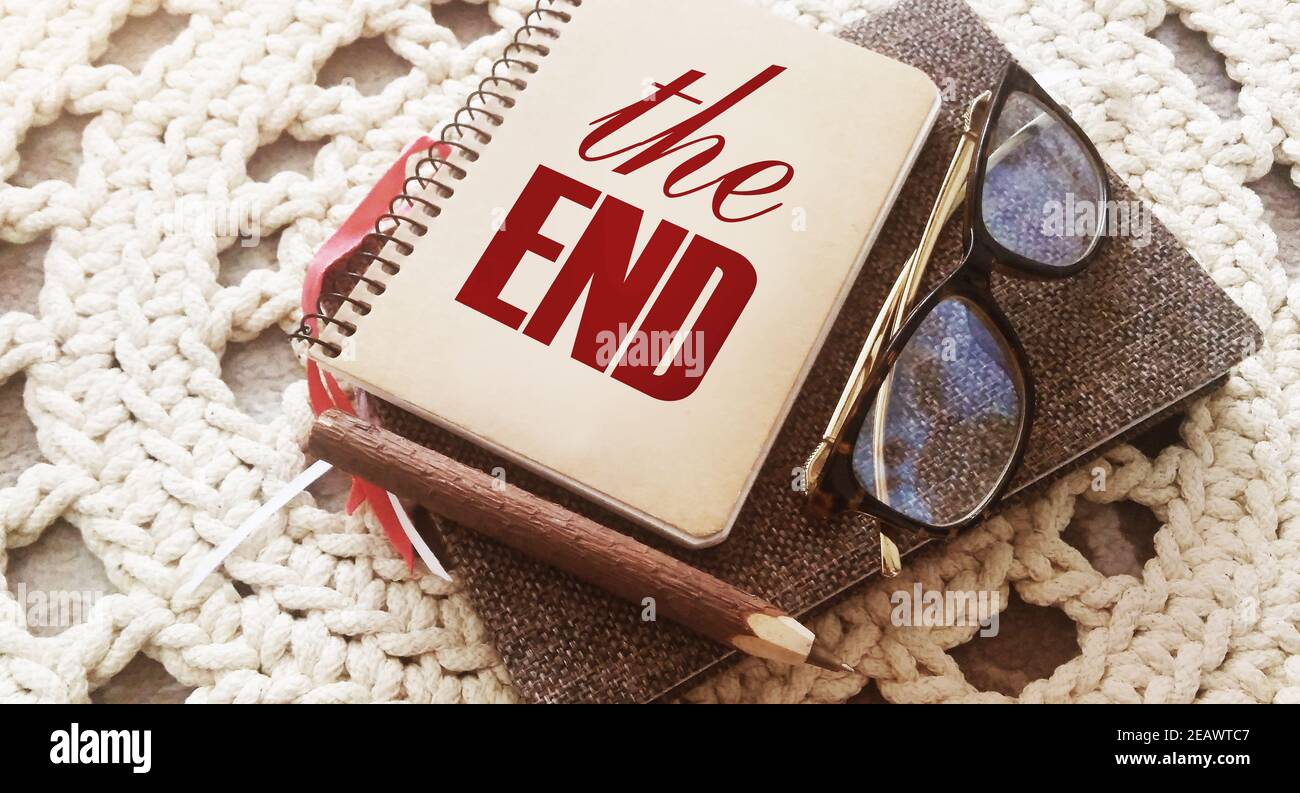 The End words on the cover of book, eyeglasses and pen. Business crisis ...