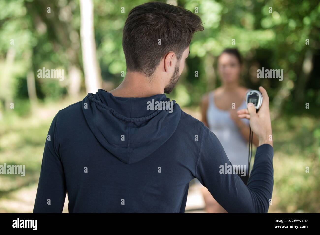 personal trainer timing a female runner Stock Photo - Alamy