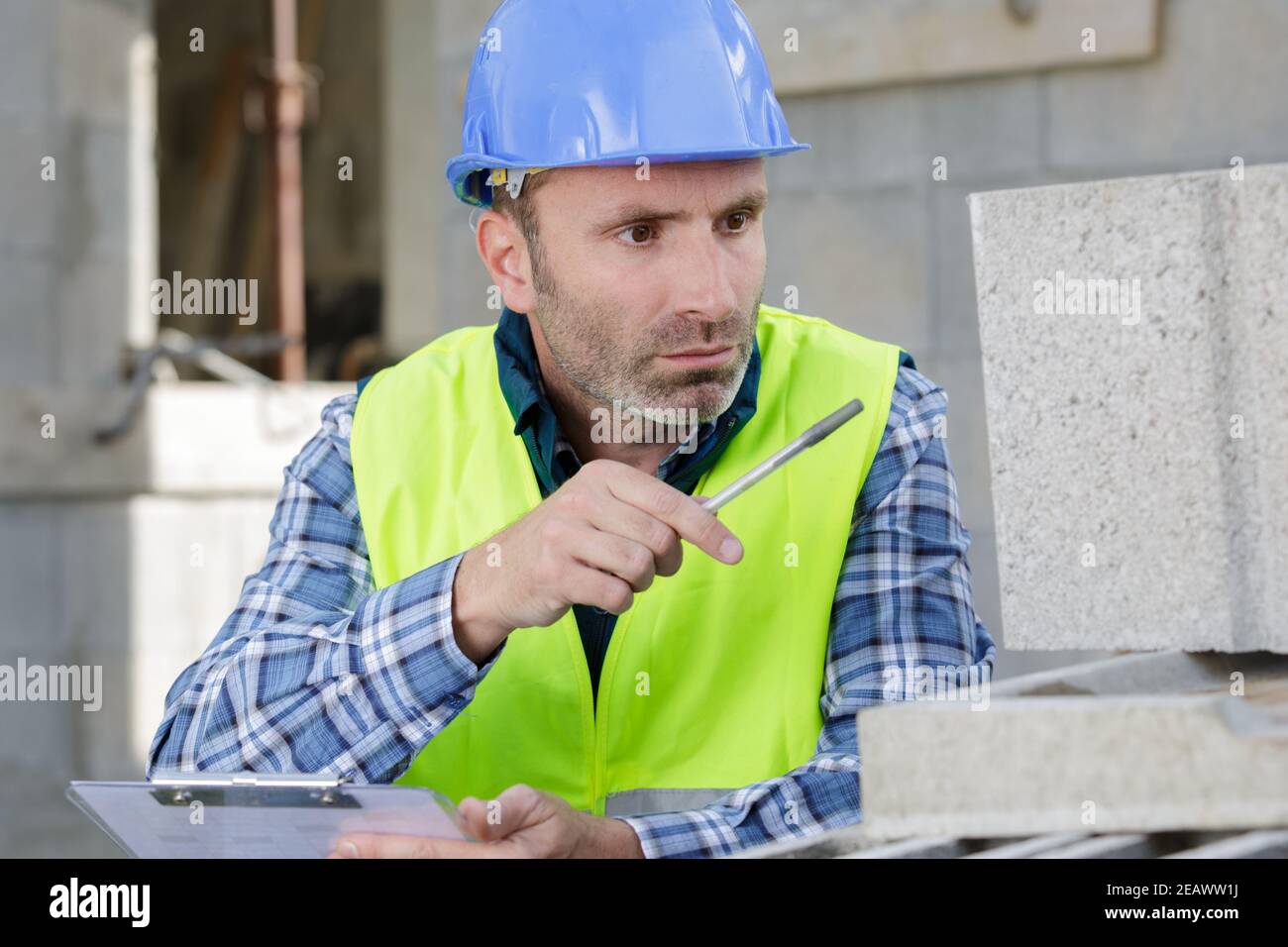 construction worker checking cement block Stock Photo - Alamy