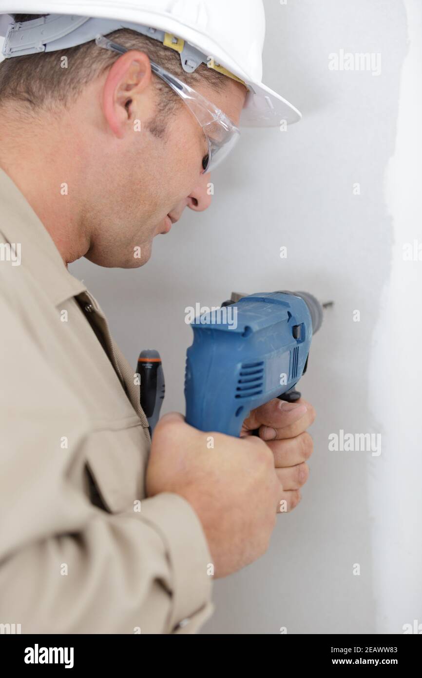 a male builder during renovation drilling Stock Photo - Alamy