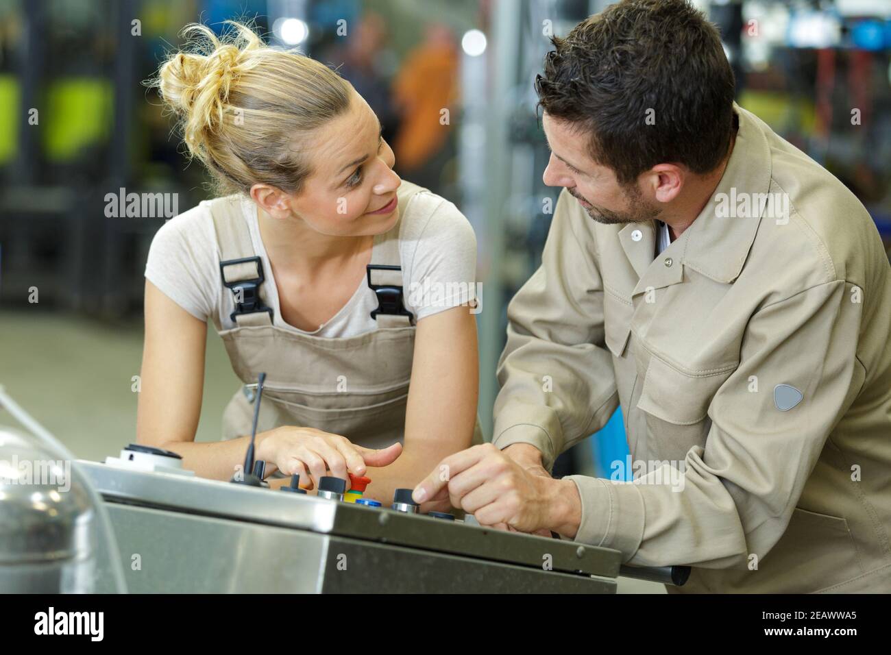 engineer showing female apprentice how to operate machinery Stock Photo ...