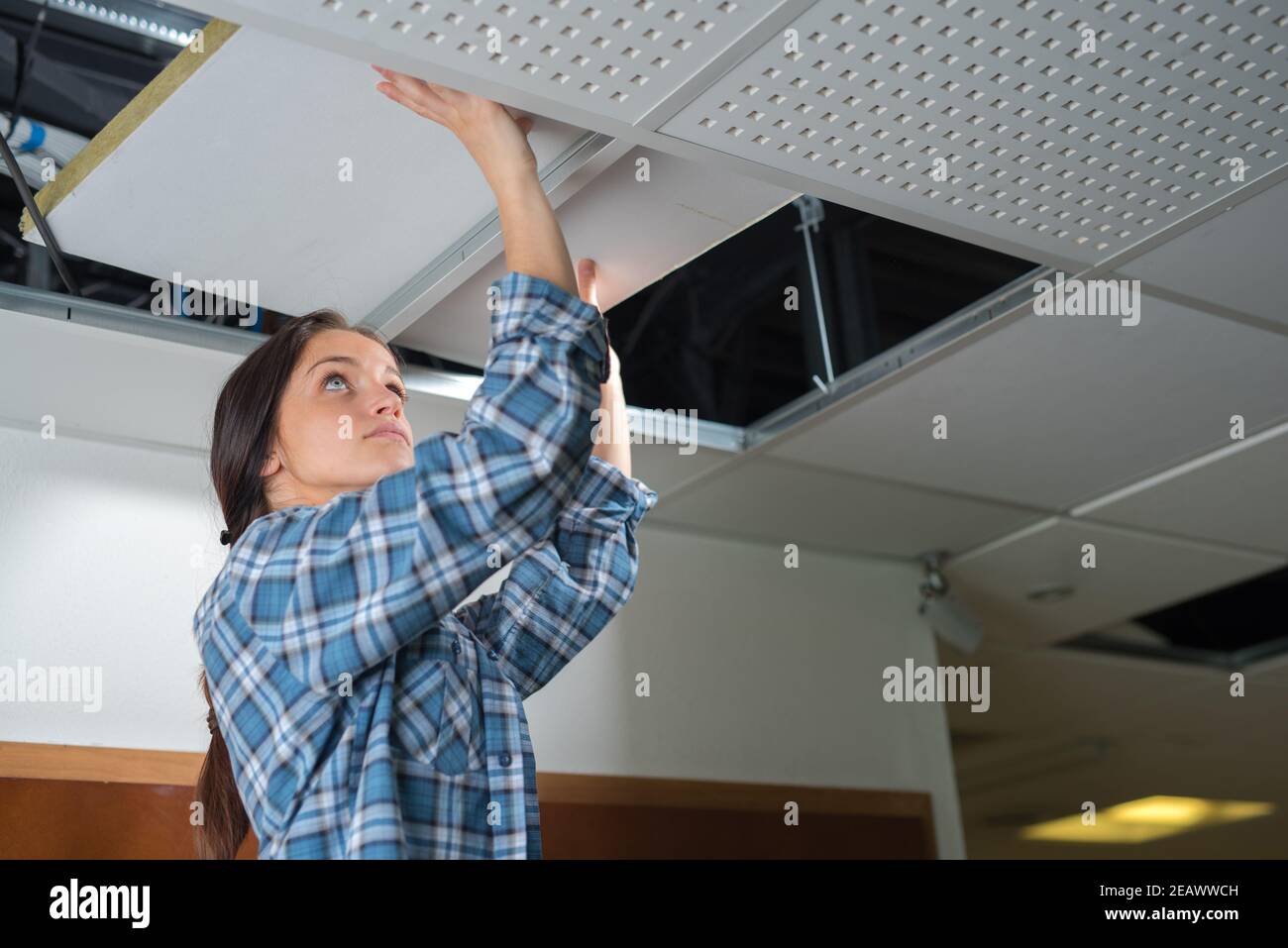 woman moving ceiling panels damaged in roof Stock Photo - Alamy