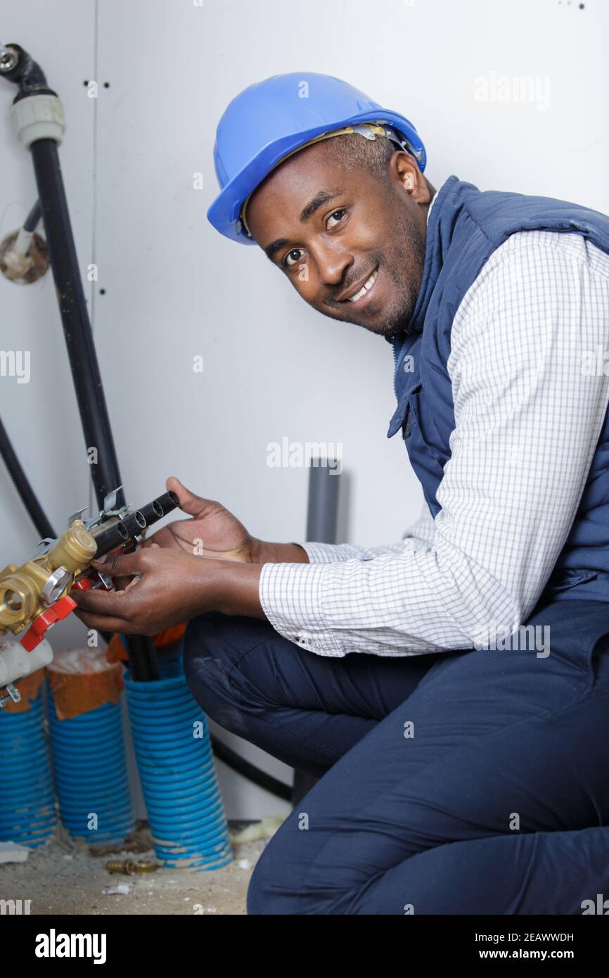portrait of an happy worker fixing pipes Stock Photo - Alamy