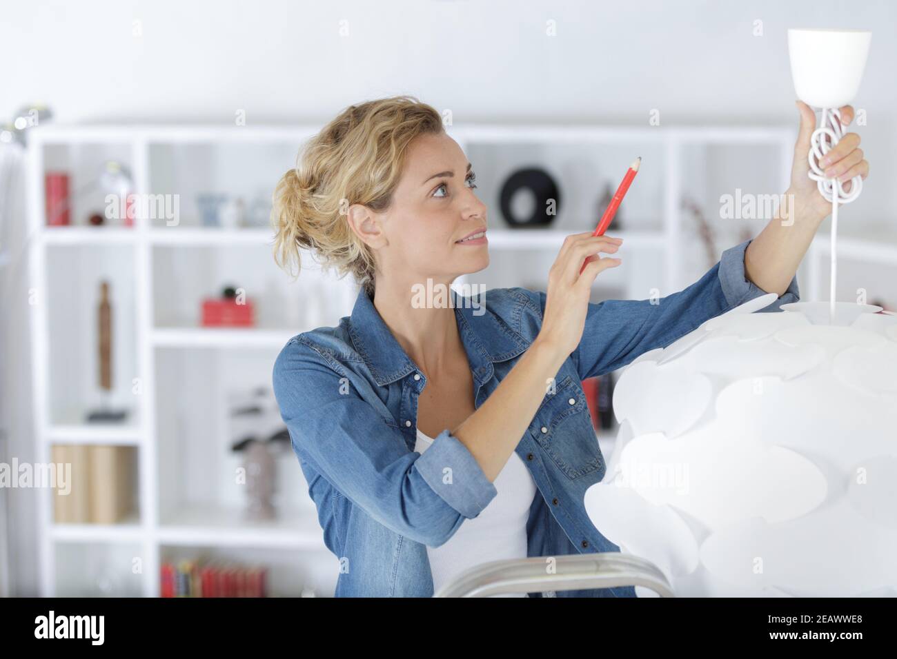 woman installing new ceiling light in her home Stock Photo - Alamy