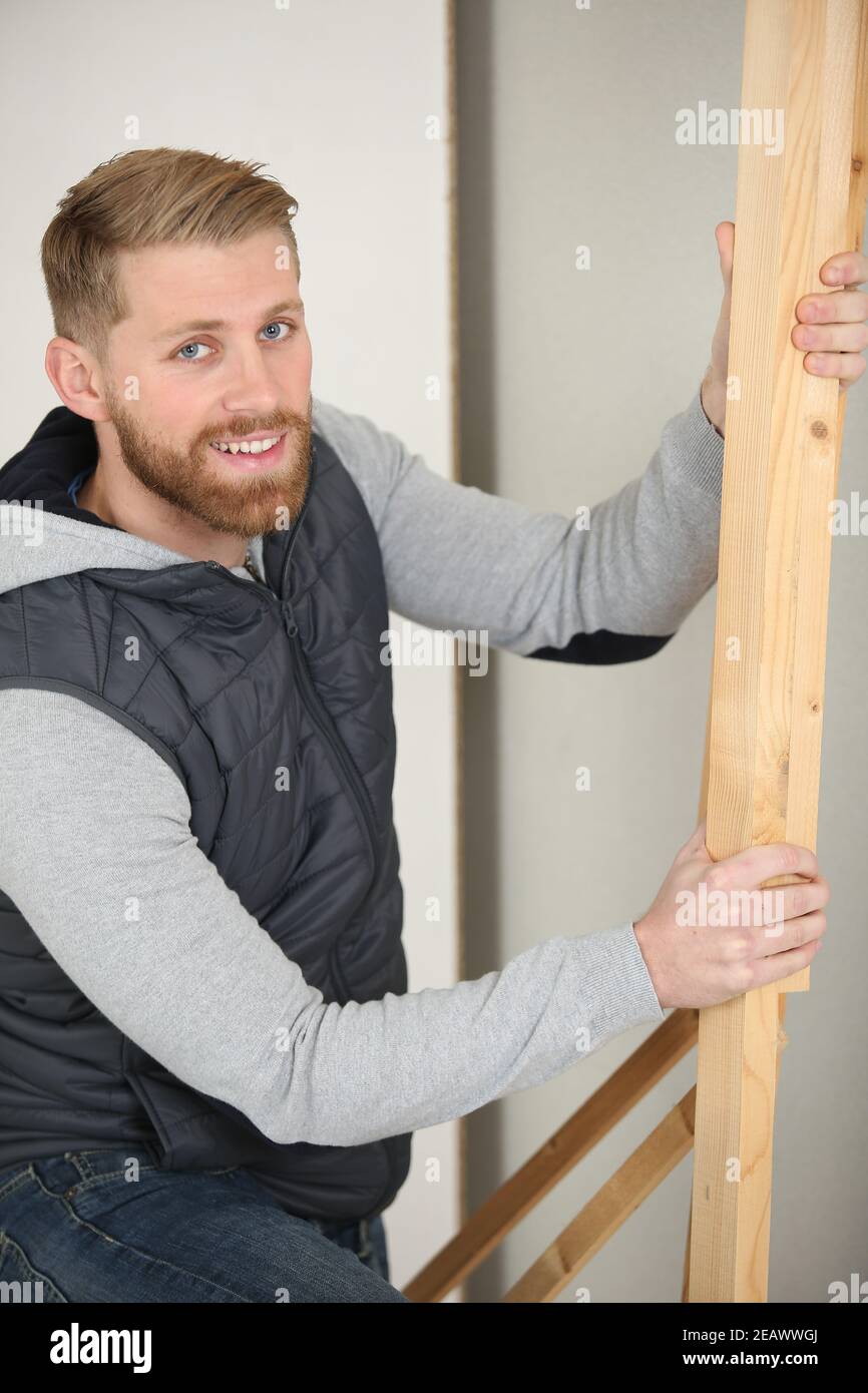 carpenter holding a length of wood Stock Photo - Alamy