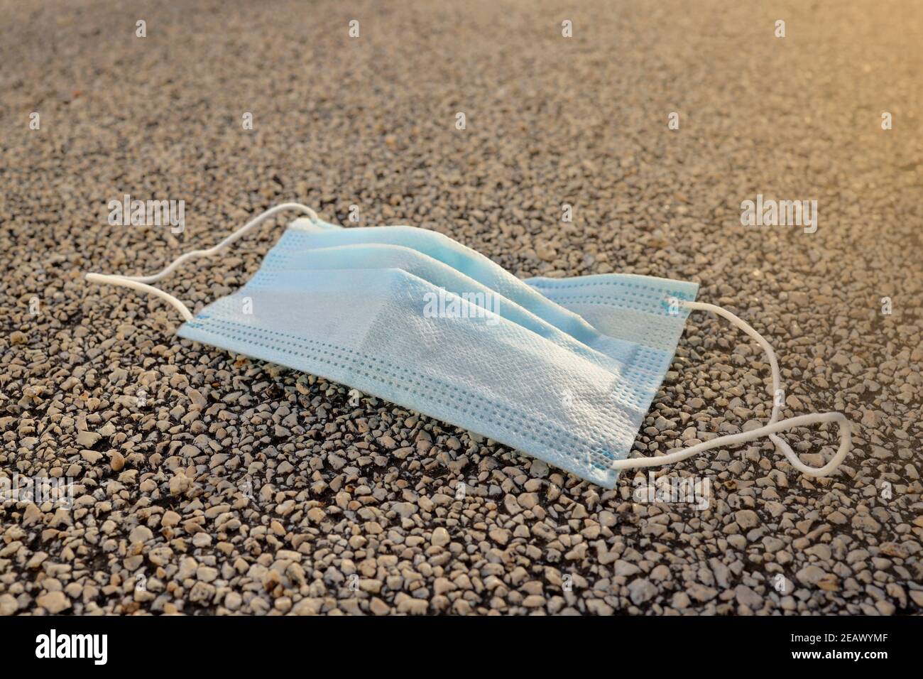 A close up Medical protective used mask thrown to the ground. Discarded ...
