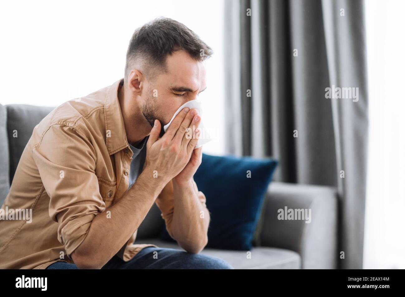 Sick caucasian guy sits on couch feel unhealthy, he suffering from ...