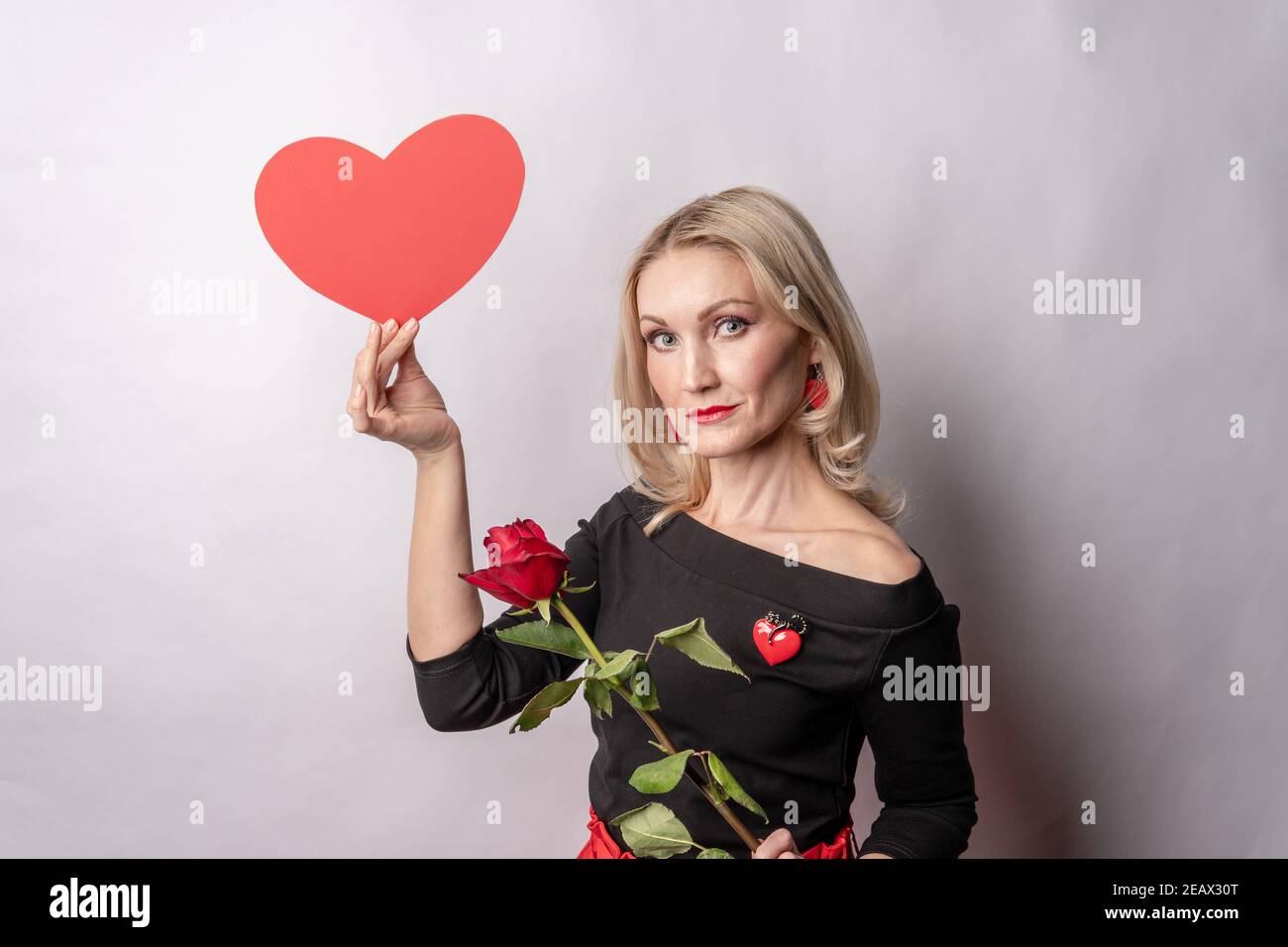 Girl holding a rose and a heart love symbol, Valentine's heart, on the ...