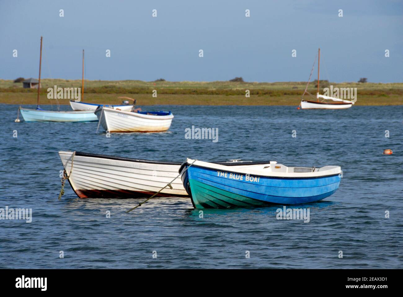 Several small dinghies floating on the water of the incoming tide ...