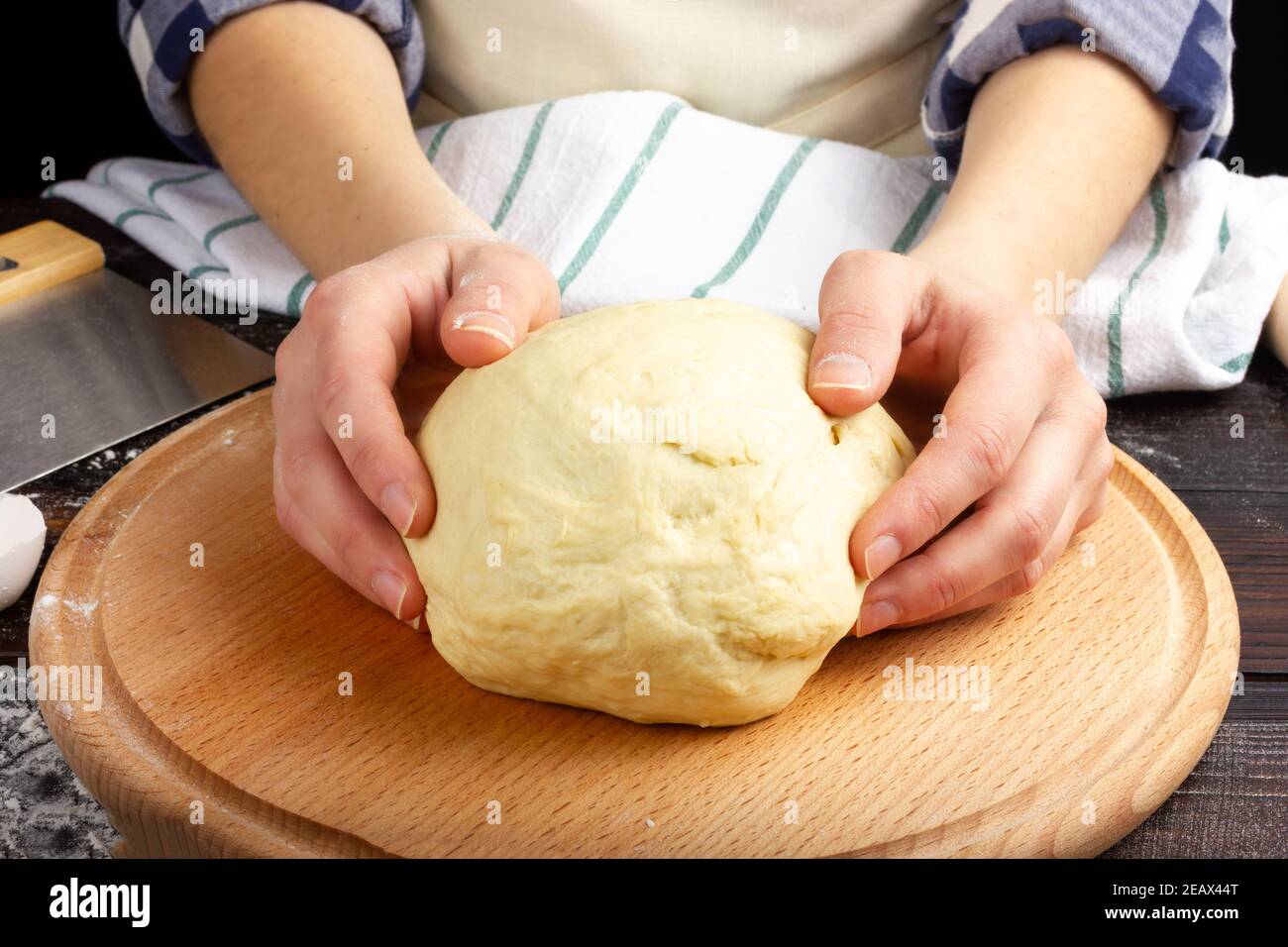 Women's hands are holding pastry. Dough preparation process. Work at ...