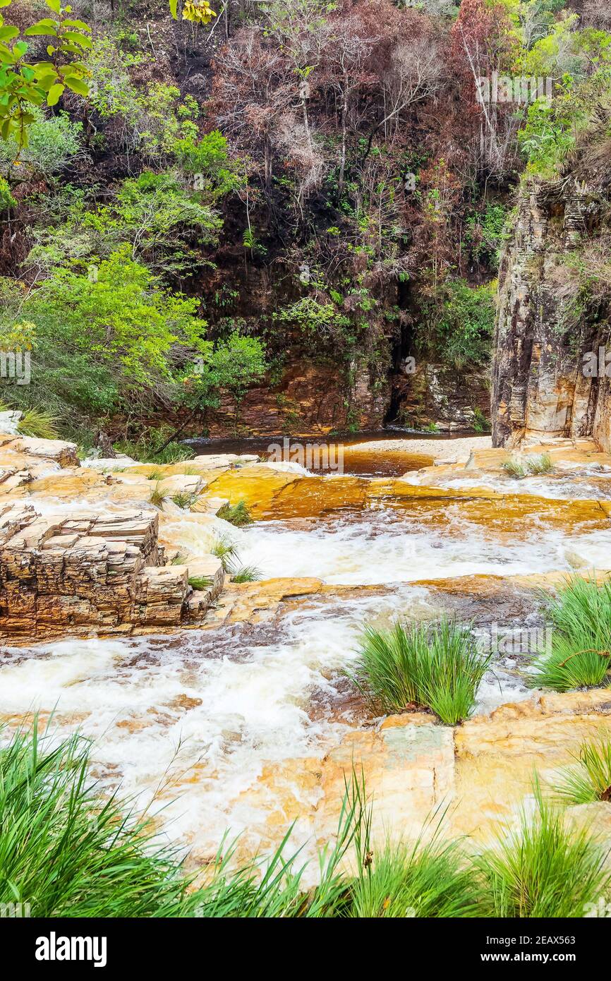 Waterfalls with golden tones, sedimentary rocks and the green ...