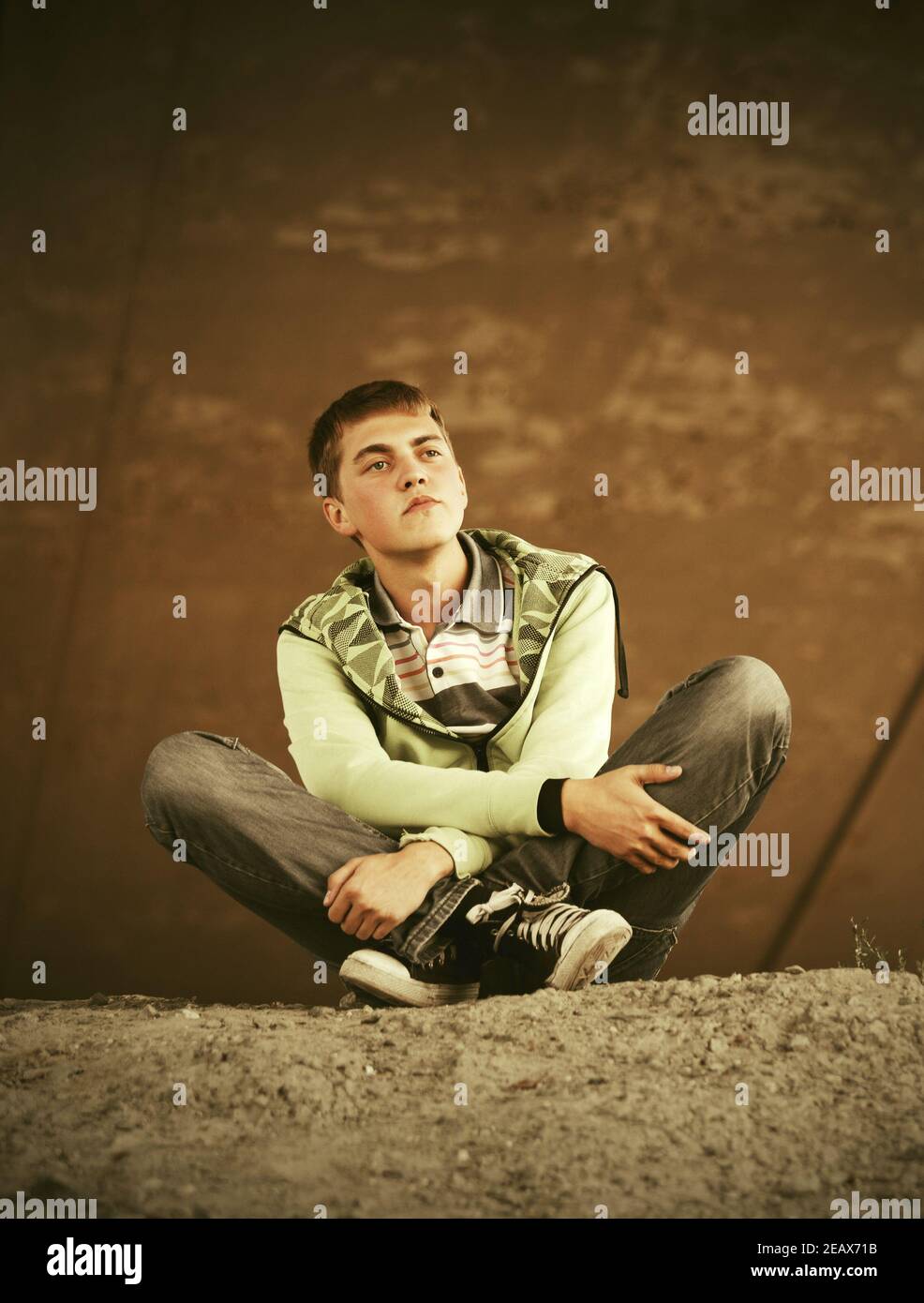 Sad teen boy in depression sitting on the ground Stylish trendy male ...