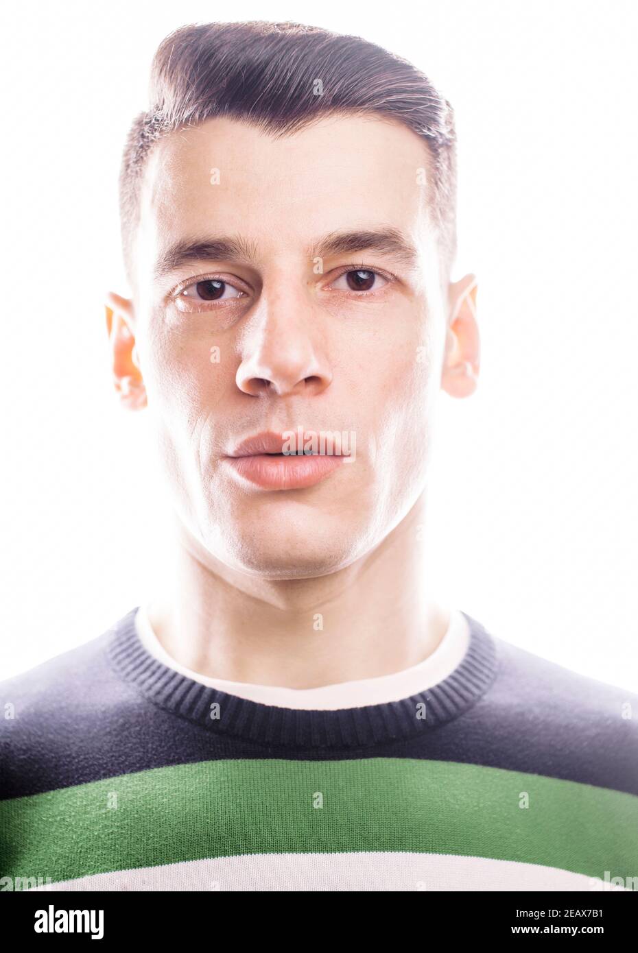 Portrait of a smart serious young man standing against white background ...
