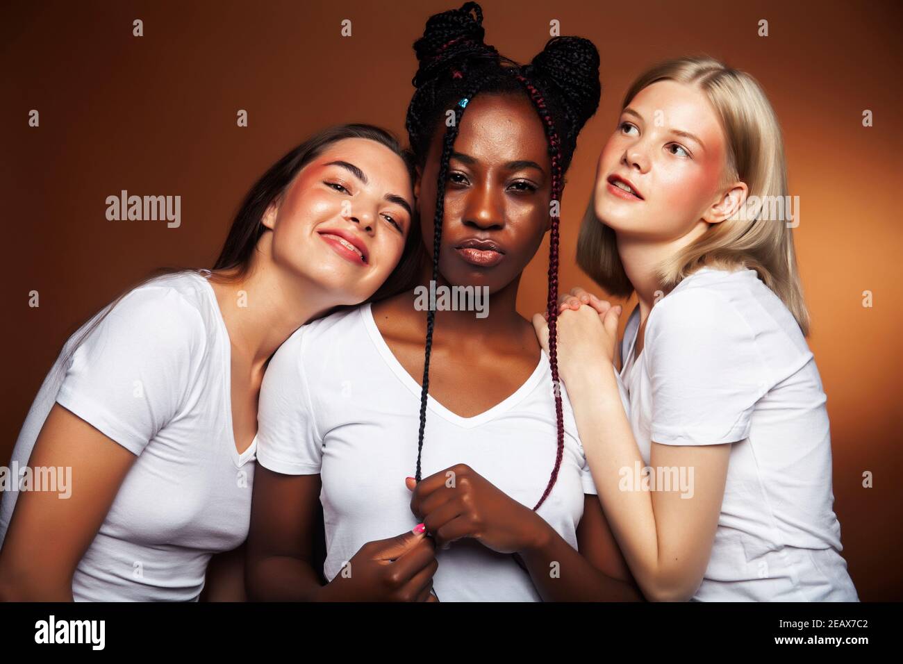 young pretty asian, caucasian, afro woman posing cheerful together on brown background ...