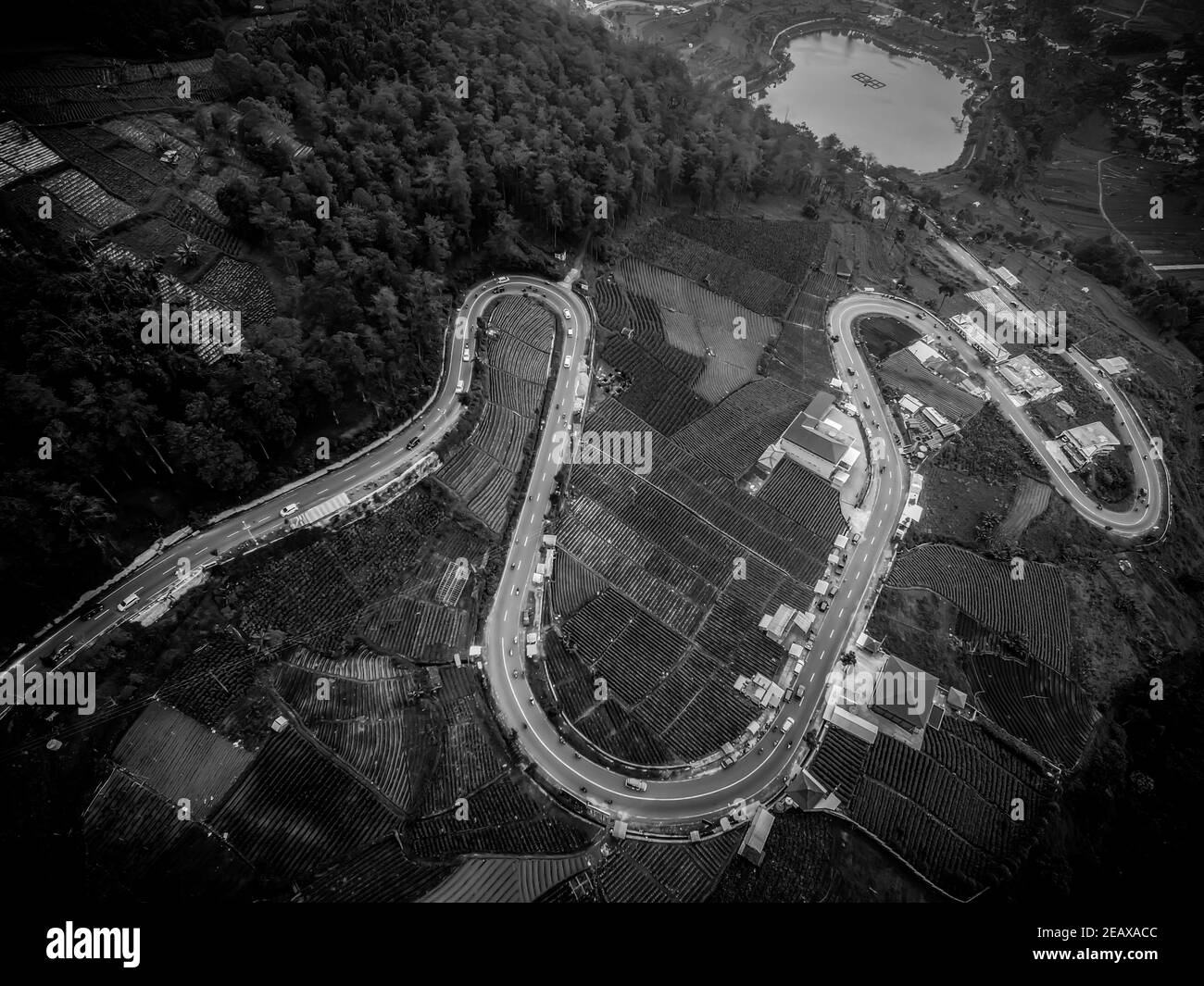 Aerial shot of highway road with agricultural farm fields in graysca ...