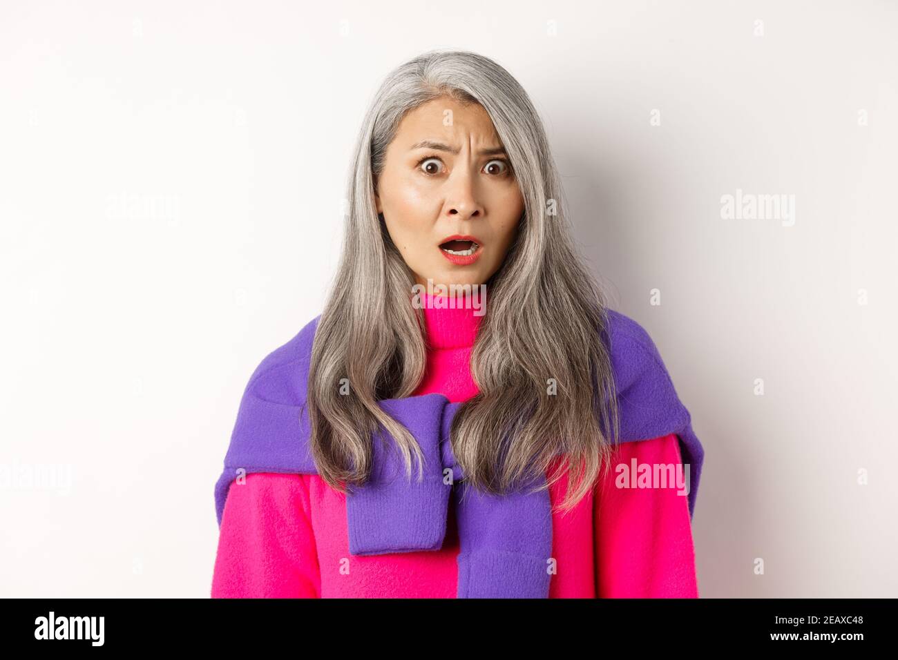 Close-up of shocked asian senior woman gasping, staring with confused ...