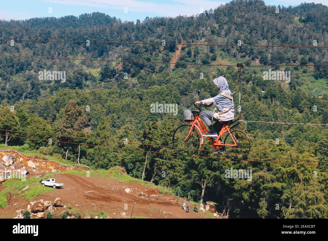 Kids play flying fox with a bike with mountain background for ...