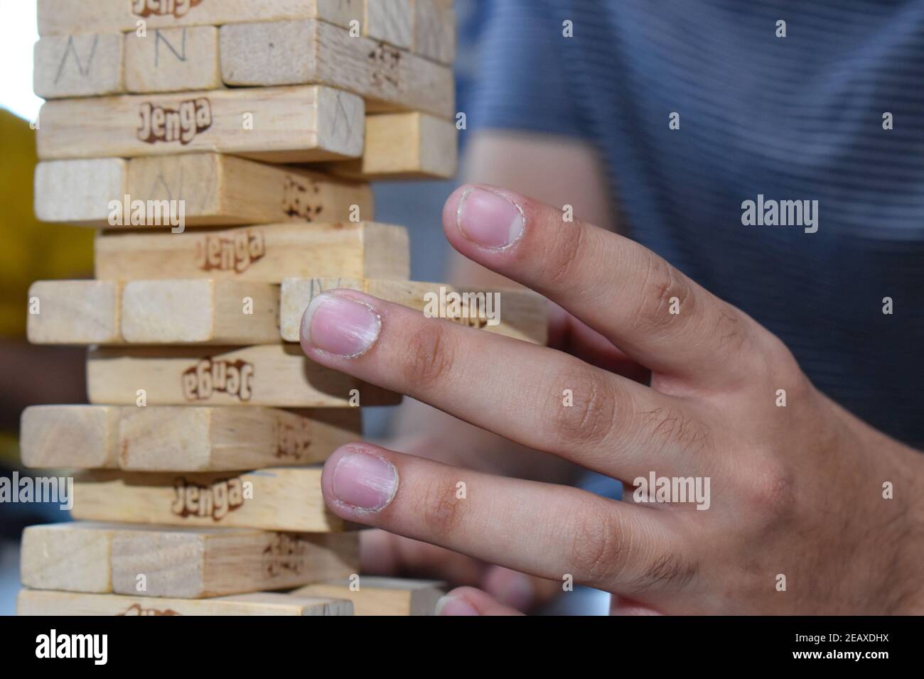 playing jenga .Close up shot of Male hand playing wooden blocks tower ...