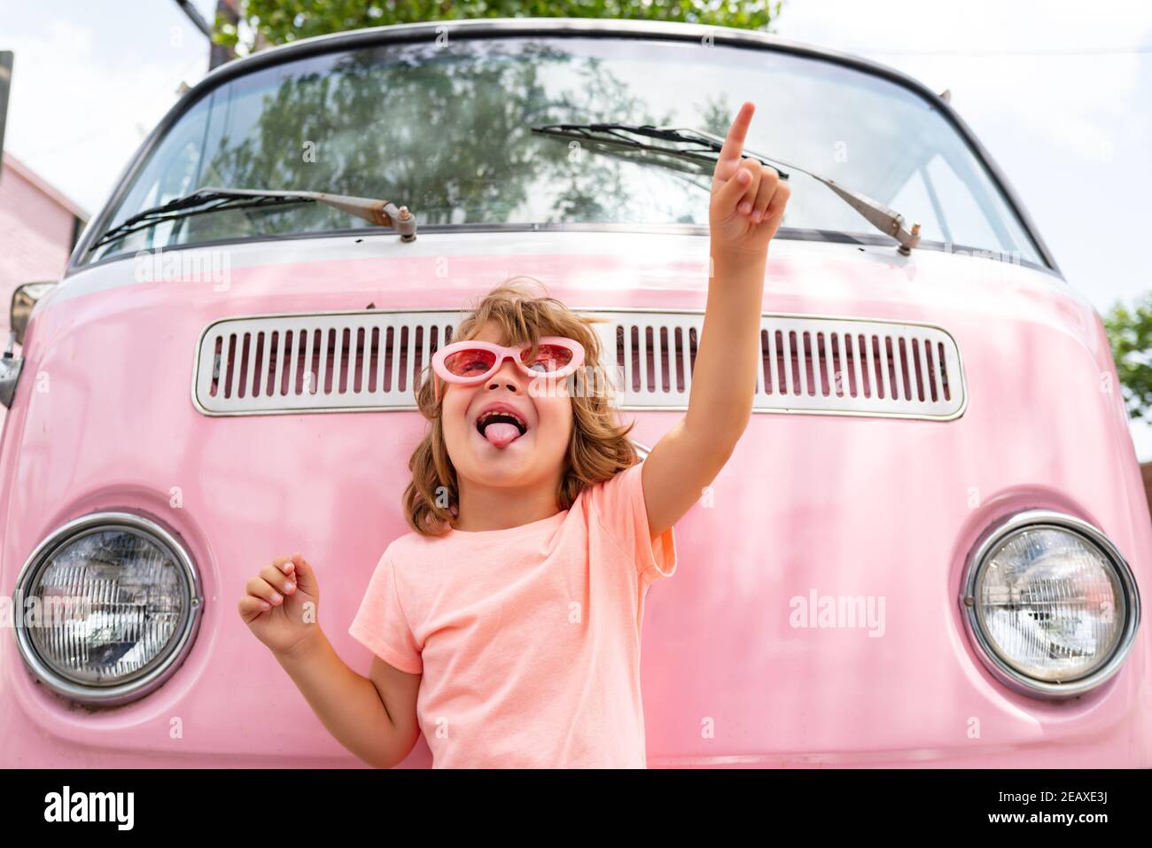 Happy child in pink retro car. Kid hippie. Happy toddler child having ...