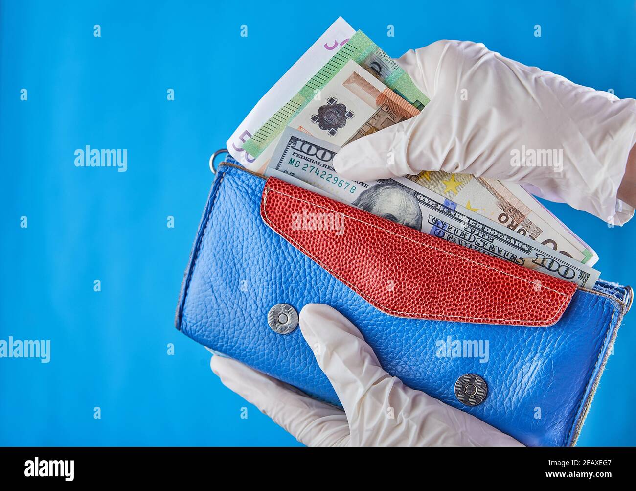 Woman taking money out of her wallet wearing rubber gloves to prevent ...