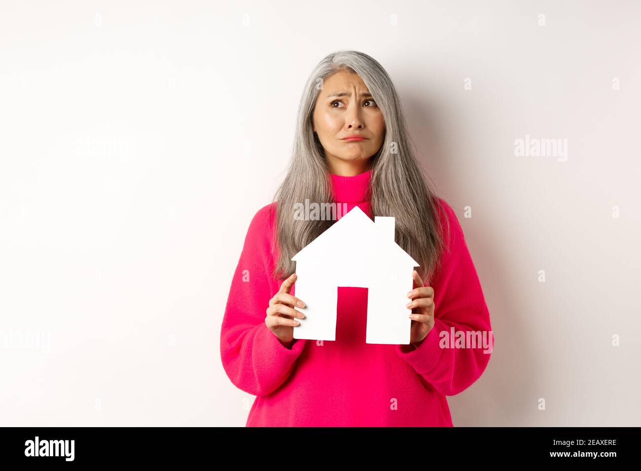 Real estate. Sad asian senior woman dreaming about own property ...