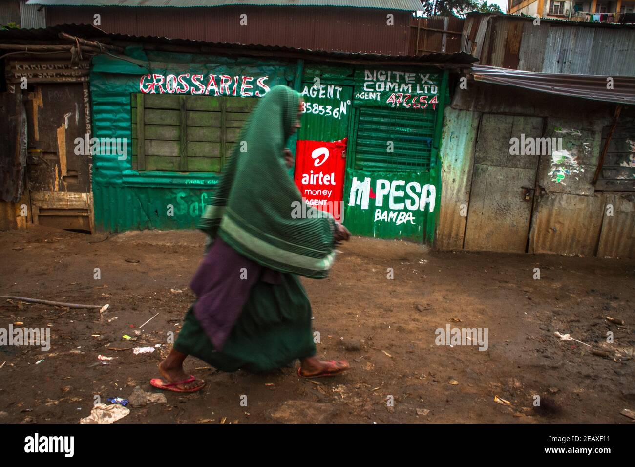 A Woman walks past a closed street Shop in Kibera Slums Stock Photo - Alamy
