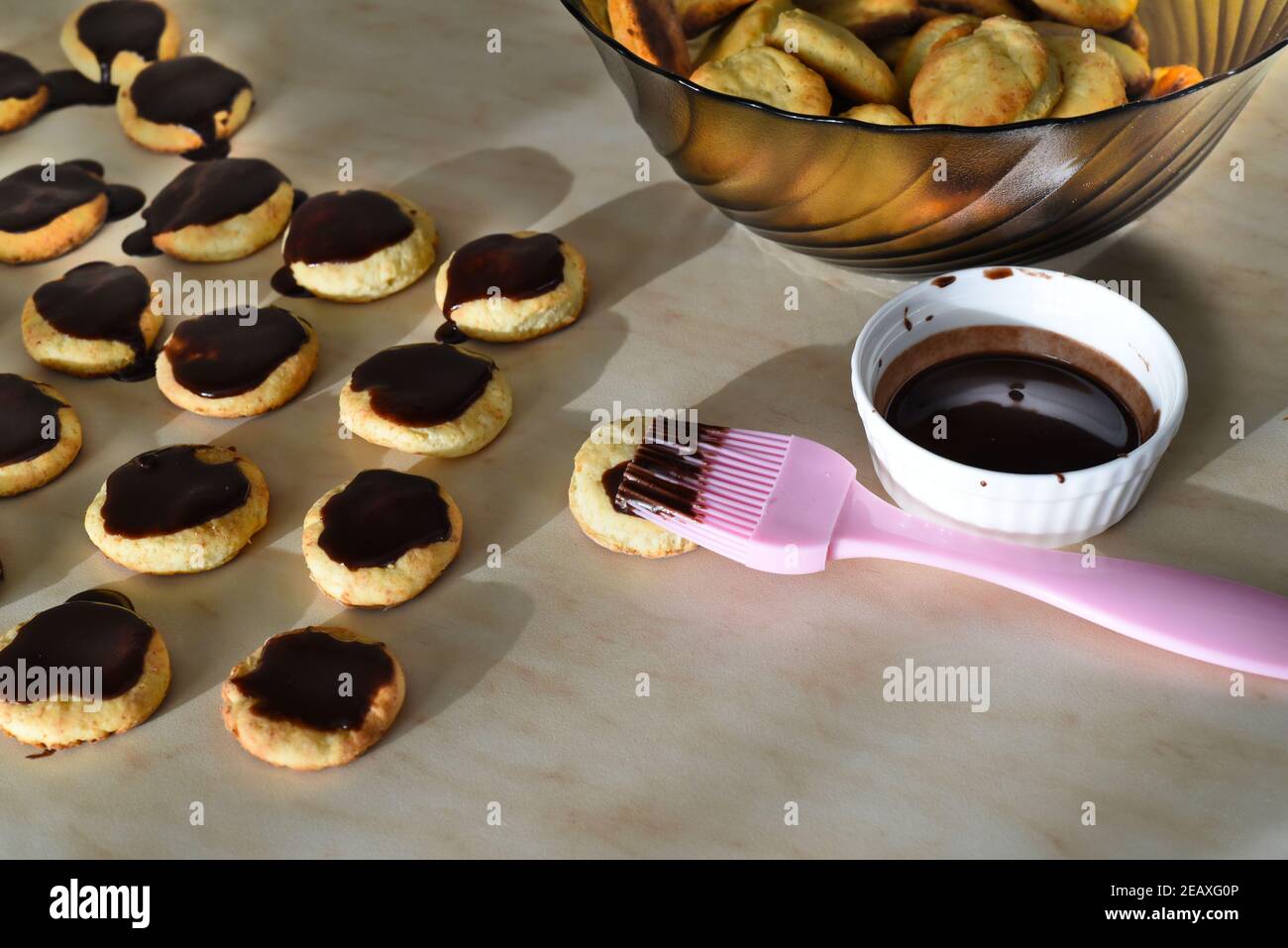 Process of coating curd biscuits with chocolate icing Stock Photo - Alamy