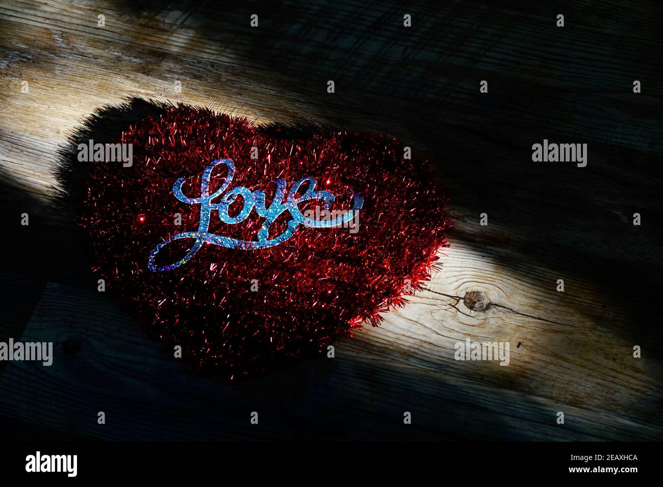 A red heart with the word love written on it with exposed by a small ...