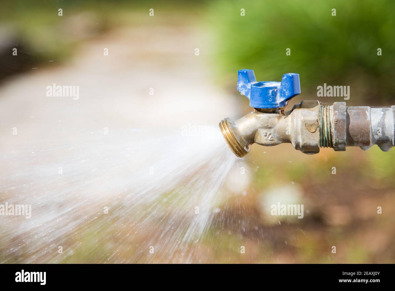 Water flowing fast from exterior tap Stock Photo - Alamy