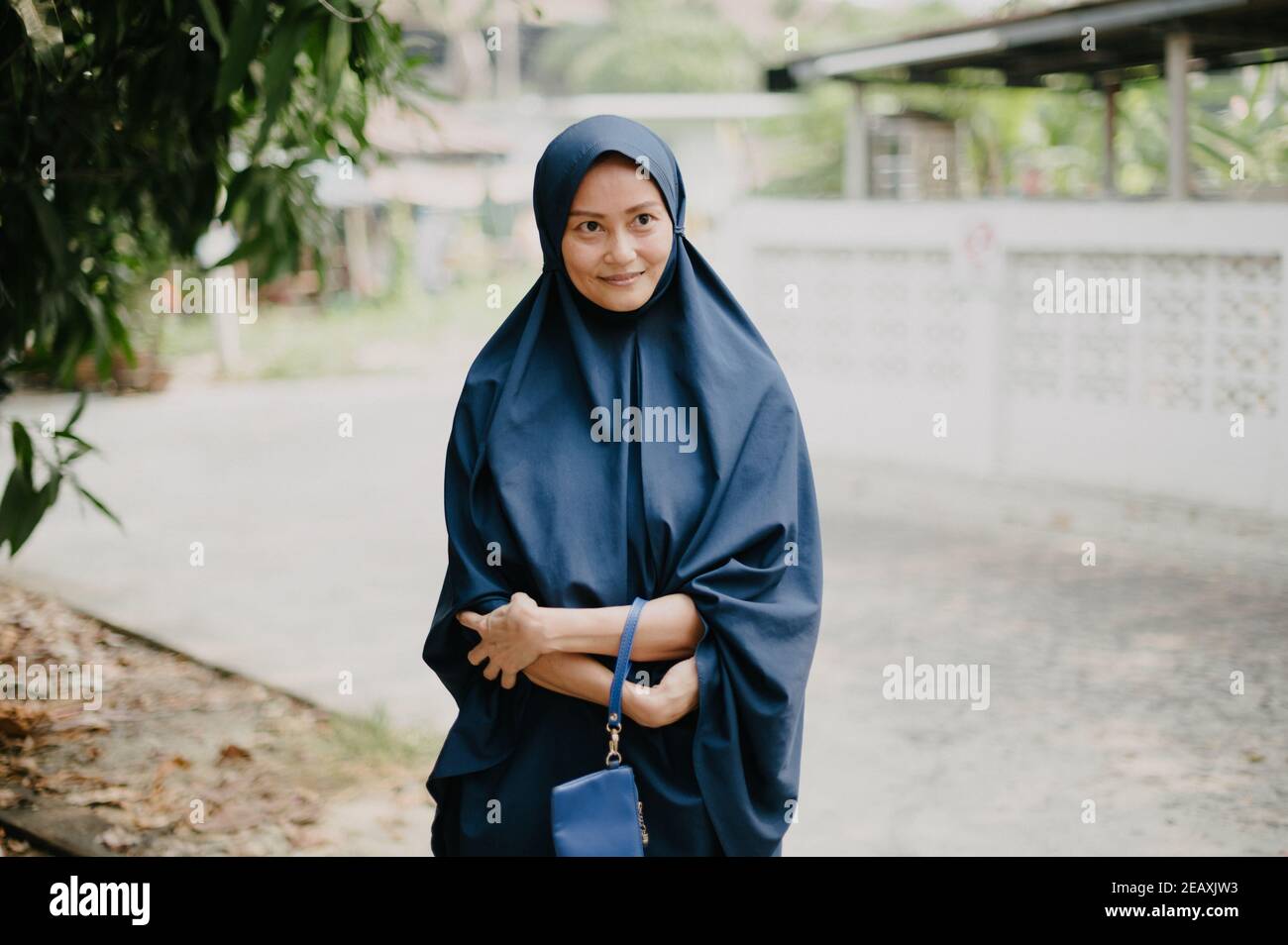Thai Muslim womam wearing a blue hijab dress, smiling Stock Photo - Alamy