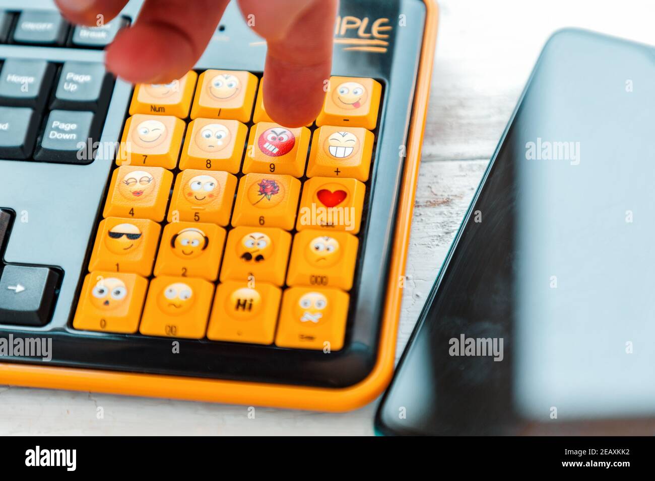 A male hand presses a button on the keyboard with an angry emoji. Close ...
