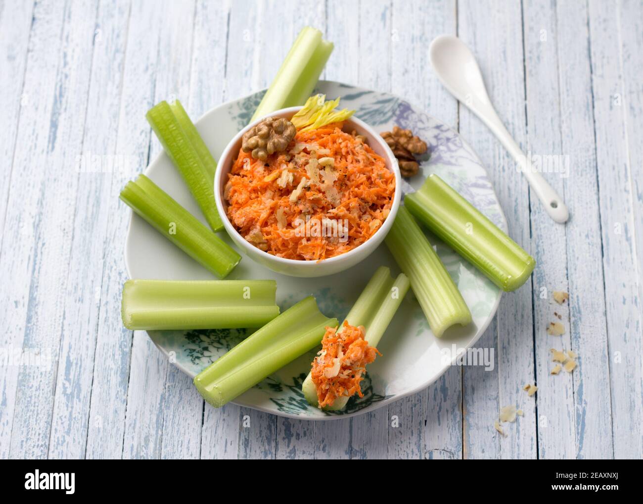 Delicious vegetable diet snack, celery stalks with carrot dip with nuts ...