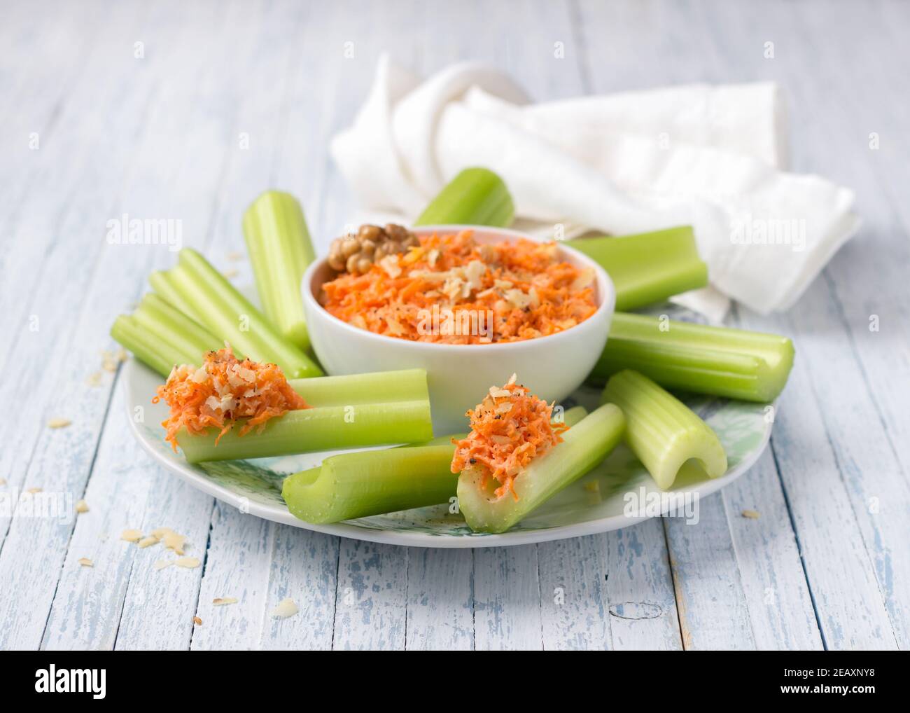 Delicious vegetable diet snack, celery stalks with carrot dip with nuts ...