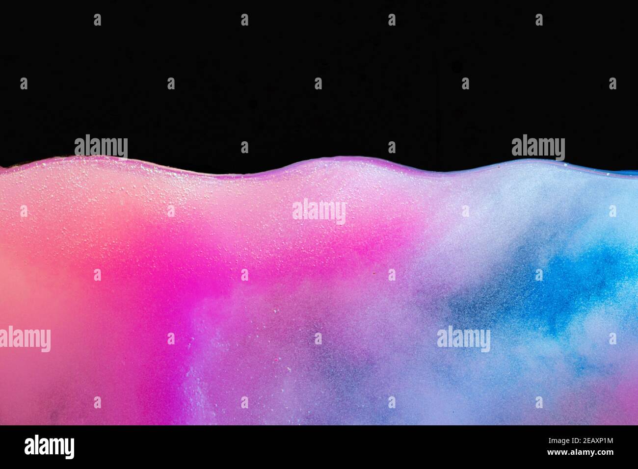 Pink bubbly boiling water against black background Stock Photo - Alamy