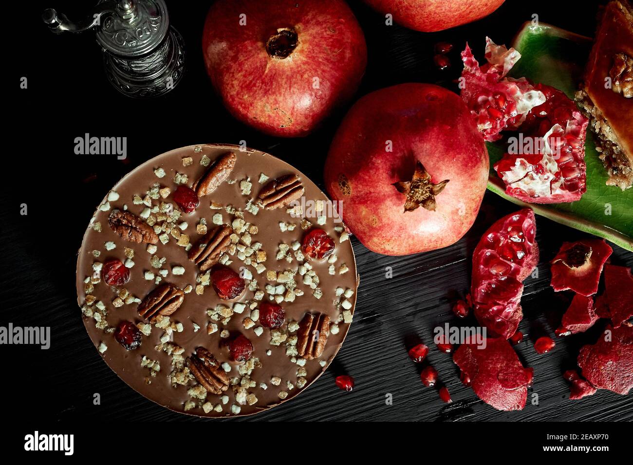 Round chocolate with nuts and dried fruits on a dark background ...