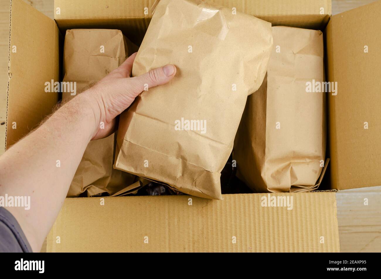 Ecological packaging and wrapping concept. Hand pulls a paper bag out ...