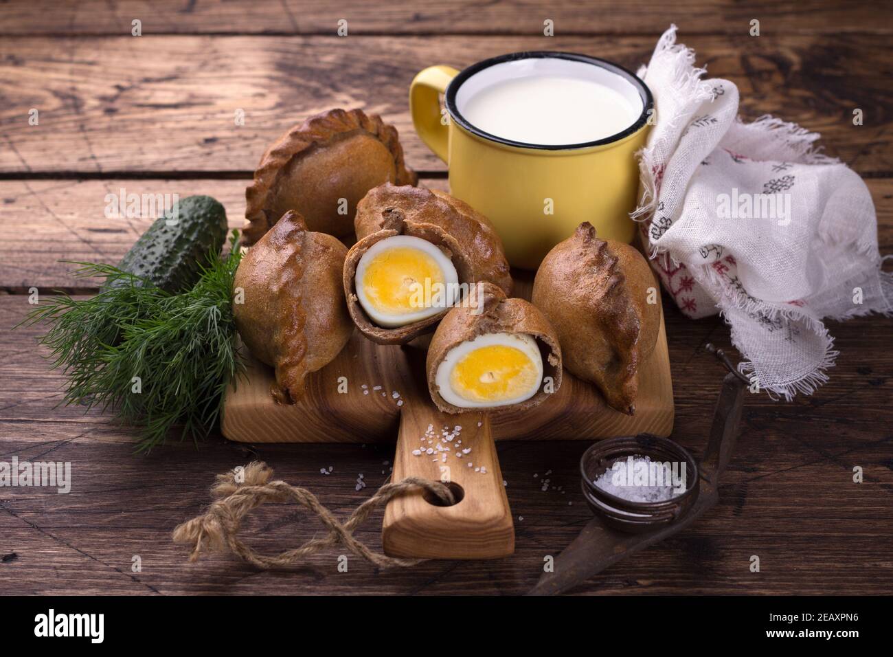 Russian traditional rye pies with egg, kokurki, on a wooden table ...