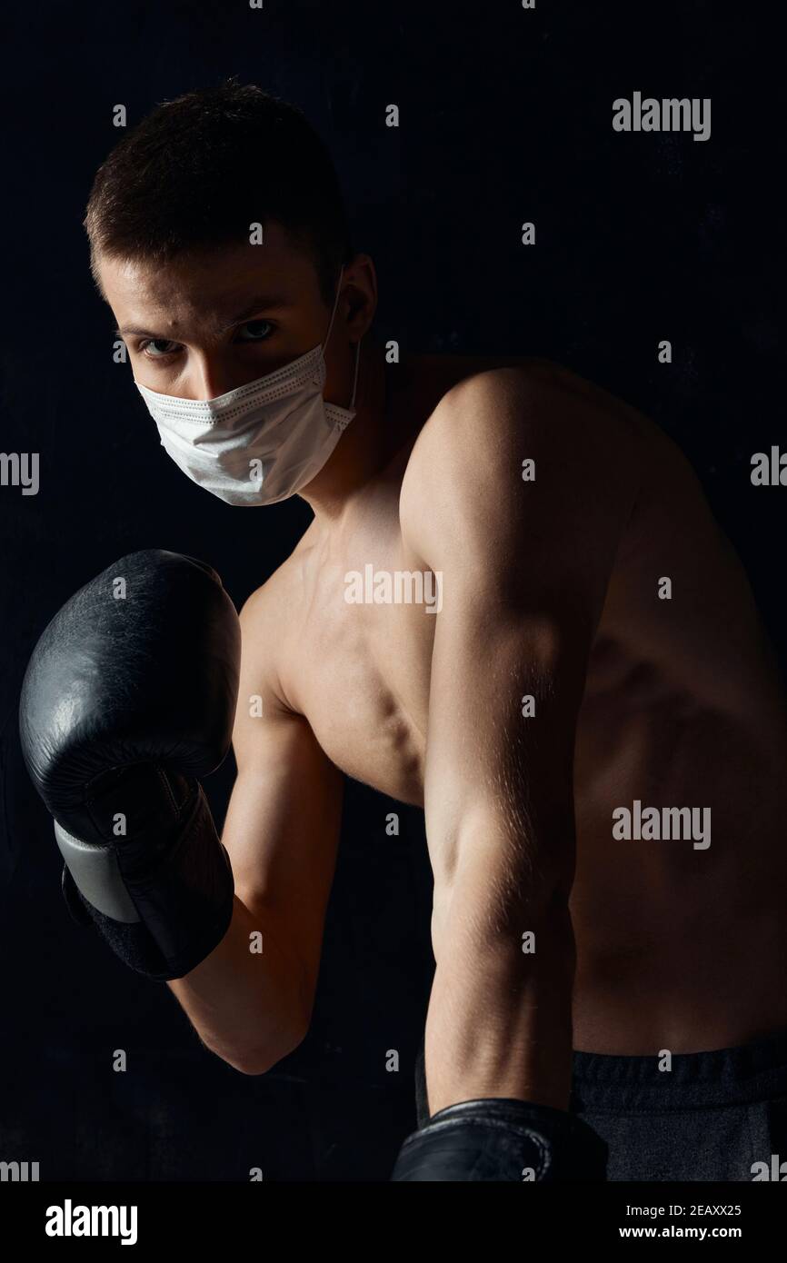 portrait of sportsman wearing boxing gloves and medical mask close-up ...
