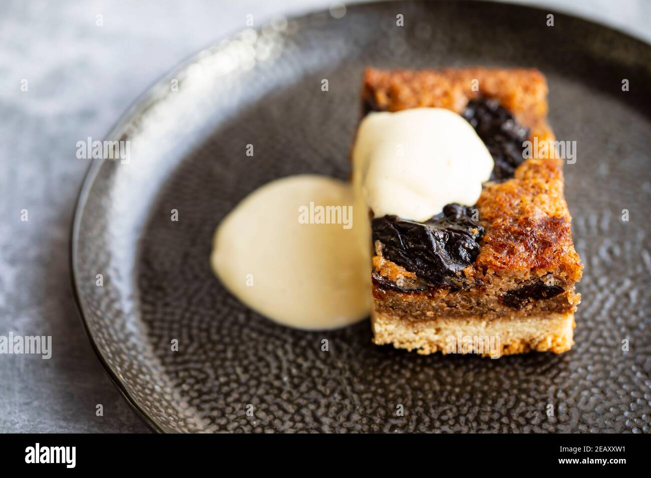 Prune and walnut cake with vanilla custard Stock Photo - Alamy